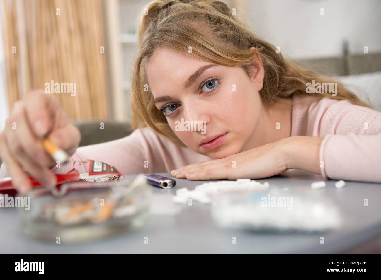 girl stubbing cigarette into ashtray Stock Photo - Alamy