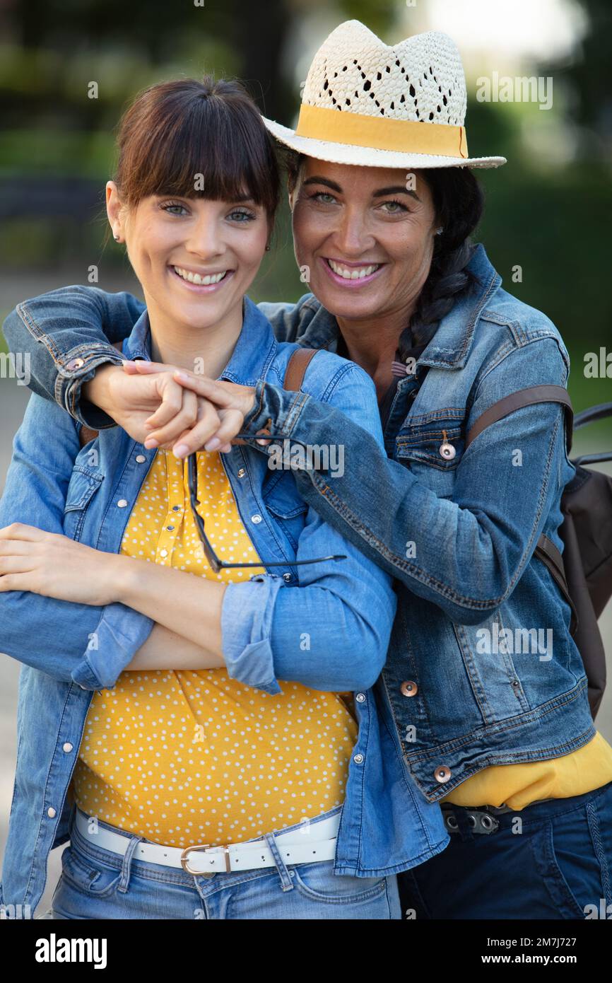 two woman hugging each other outdoors and laughing Stock Photo - Alamy