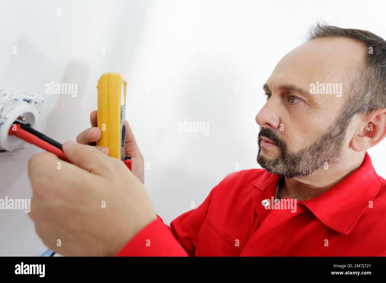 mature male electrician testing socket with multimeter Stock Photo - Alamy