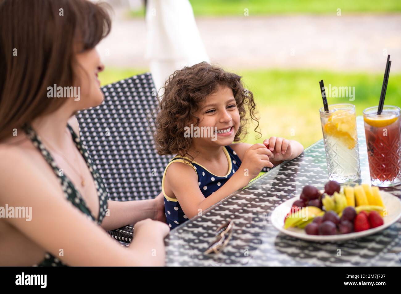 Mom and daughter having fruits and looking happy Stock Photo - Alamy
