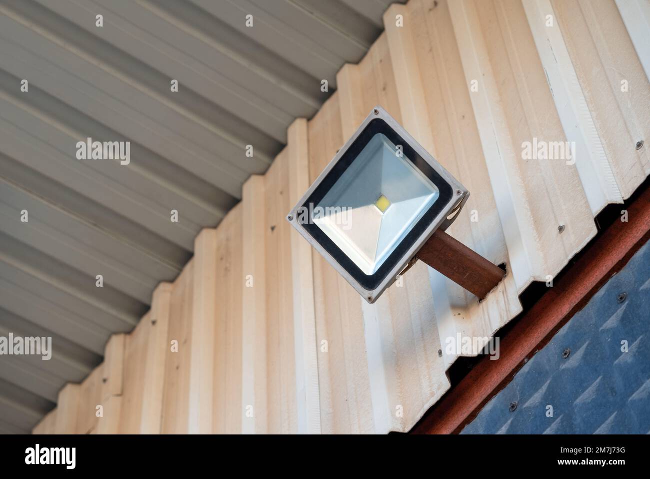 Solar powered led spotlight mounted on the outer wall of the warehouse ...