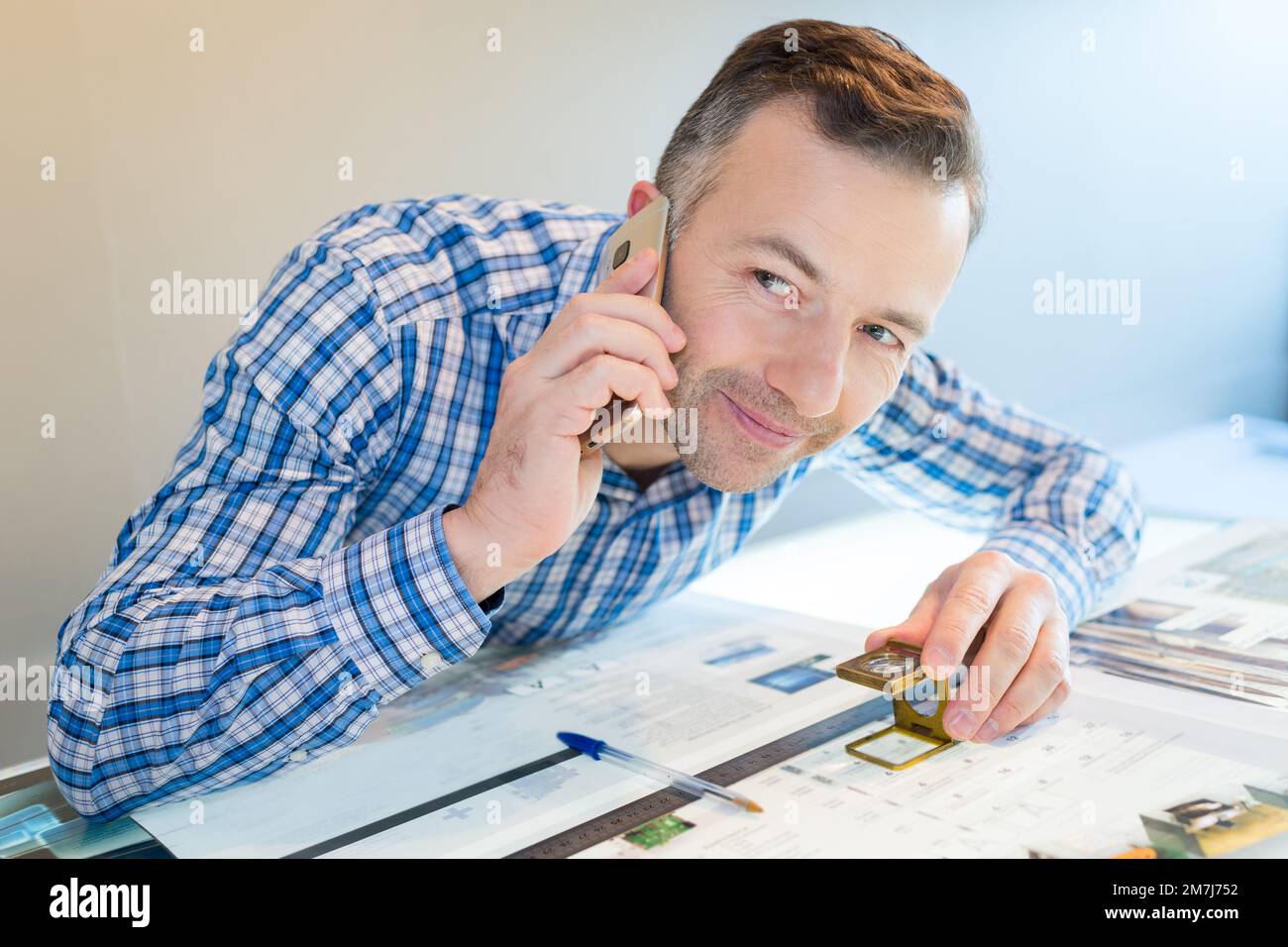 man taking phone call while proof reading Stock Photo - Alamy