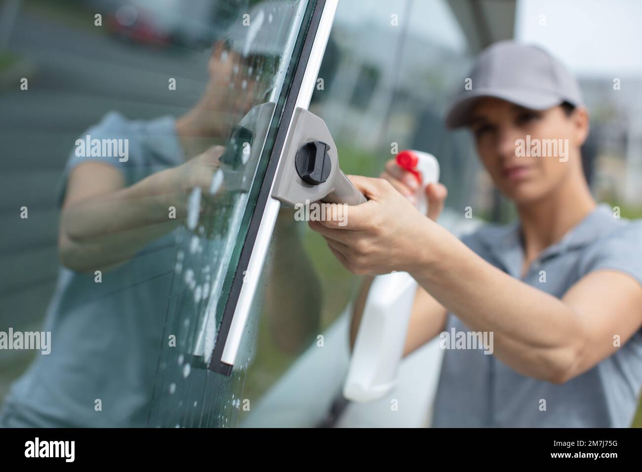 female cleaning windows with detergent spray Stock Photo - Alamy