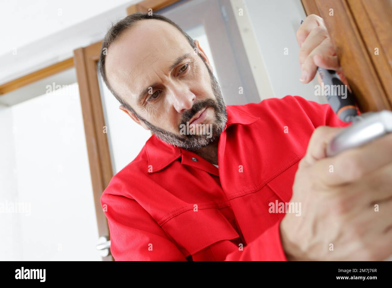 carpenter at door lock installation or repair Stock Photo - Alamy