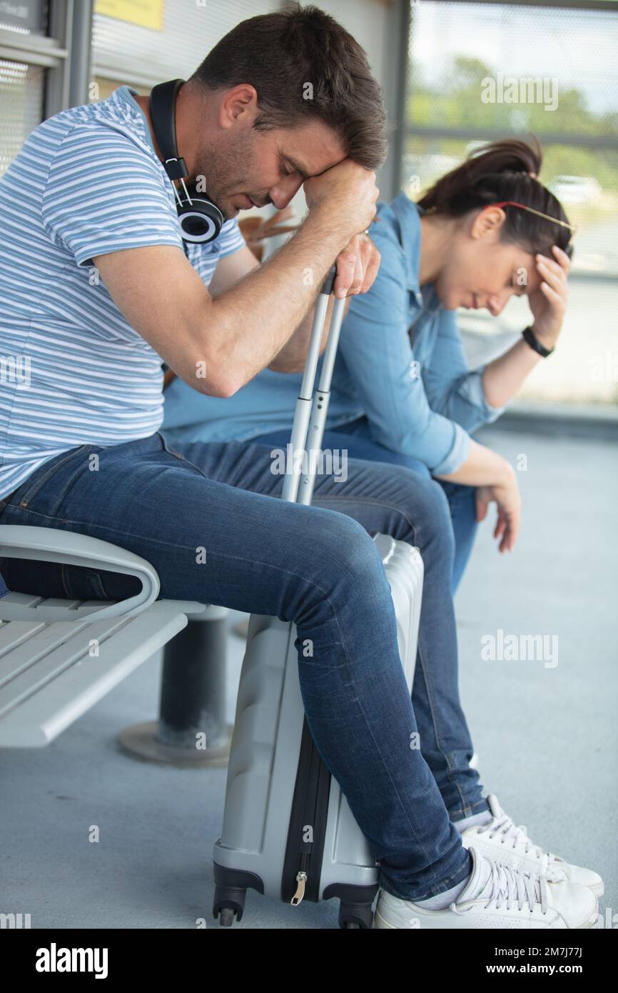 disappointed couple waiting at bus stop Stock Photo - Alamy