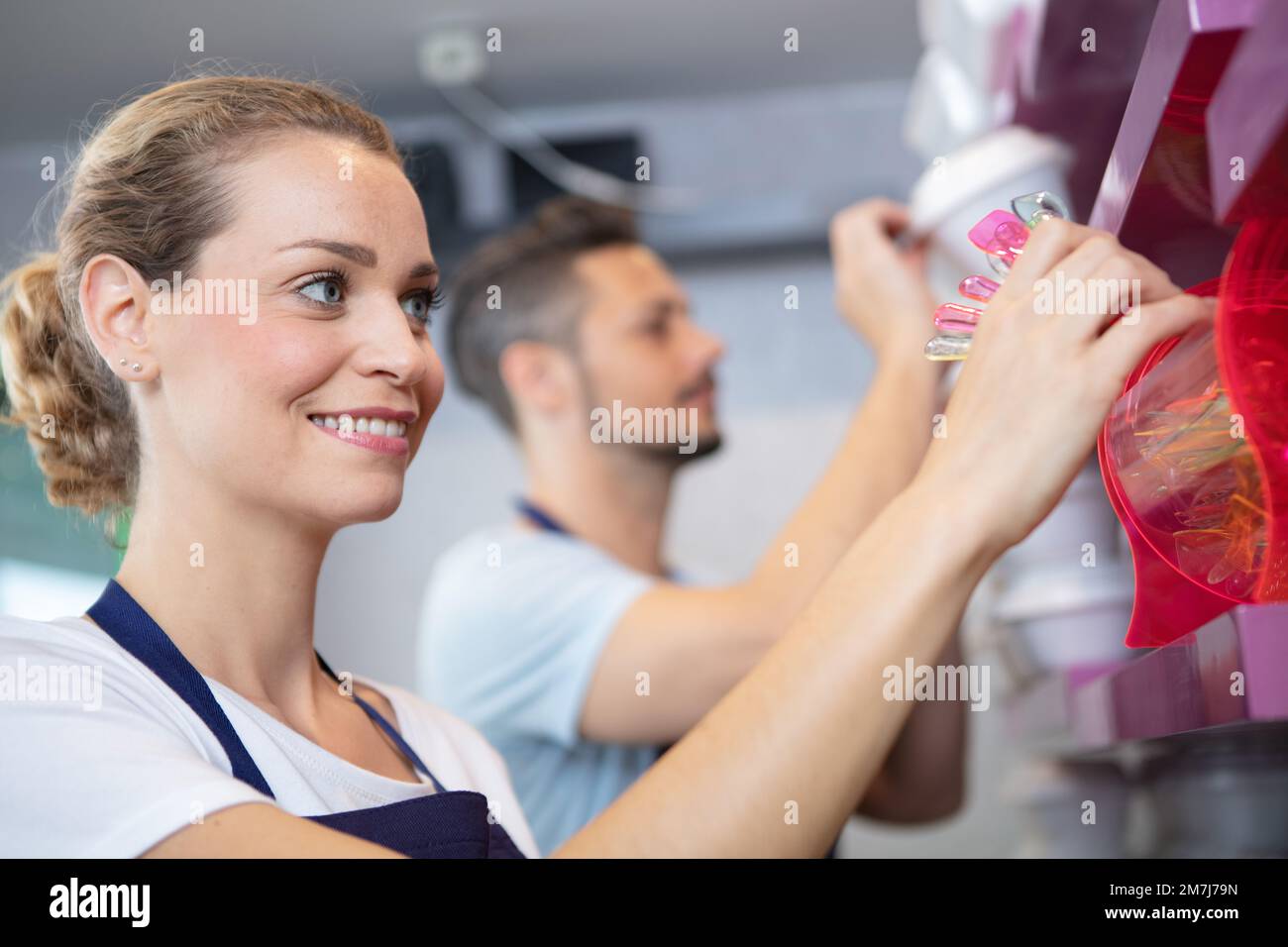 female worker holding plastic spoons in ice cream parlor Stock Photo ...