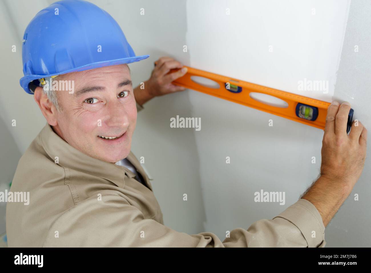 happy smiling constructor holding tool Stock Photo - Alamy