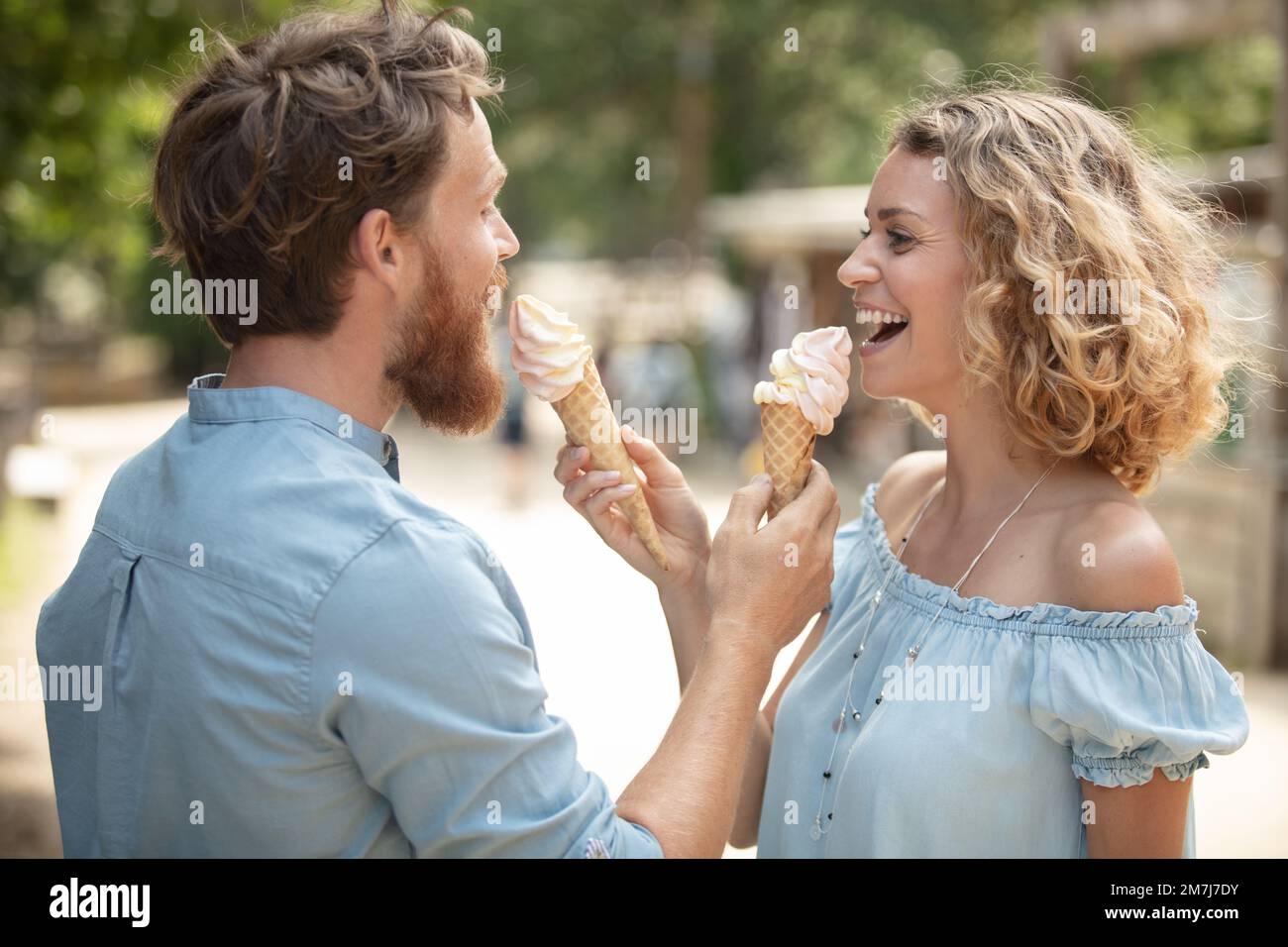 romantic couple eating ice cream at park Stock Photo - Alamy