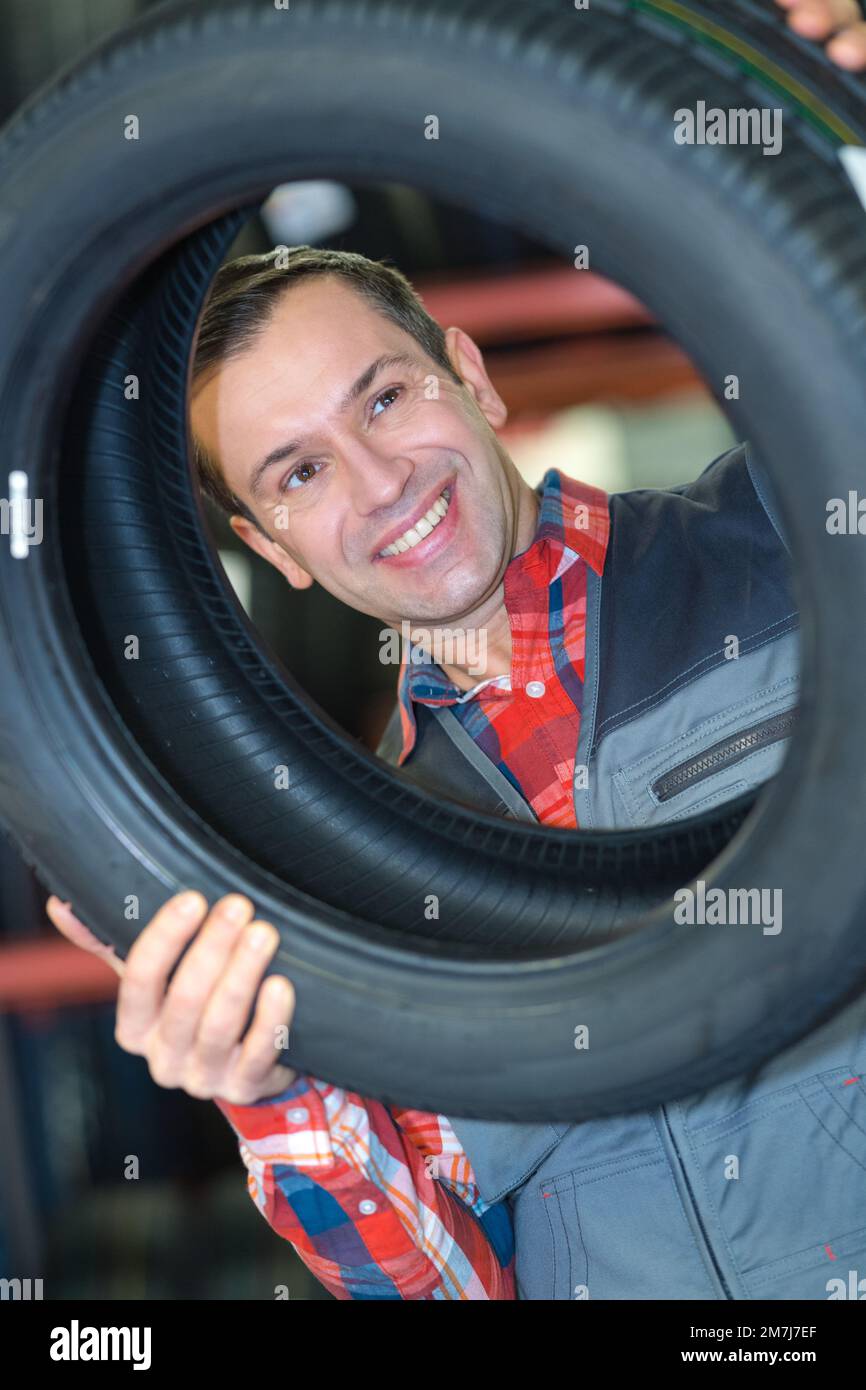 man holding tire rubber smiling Stock Photo - Alamy