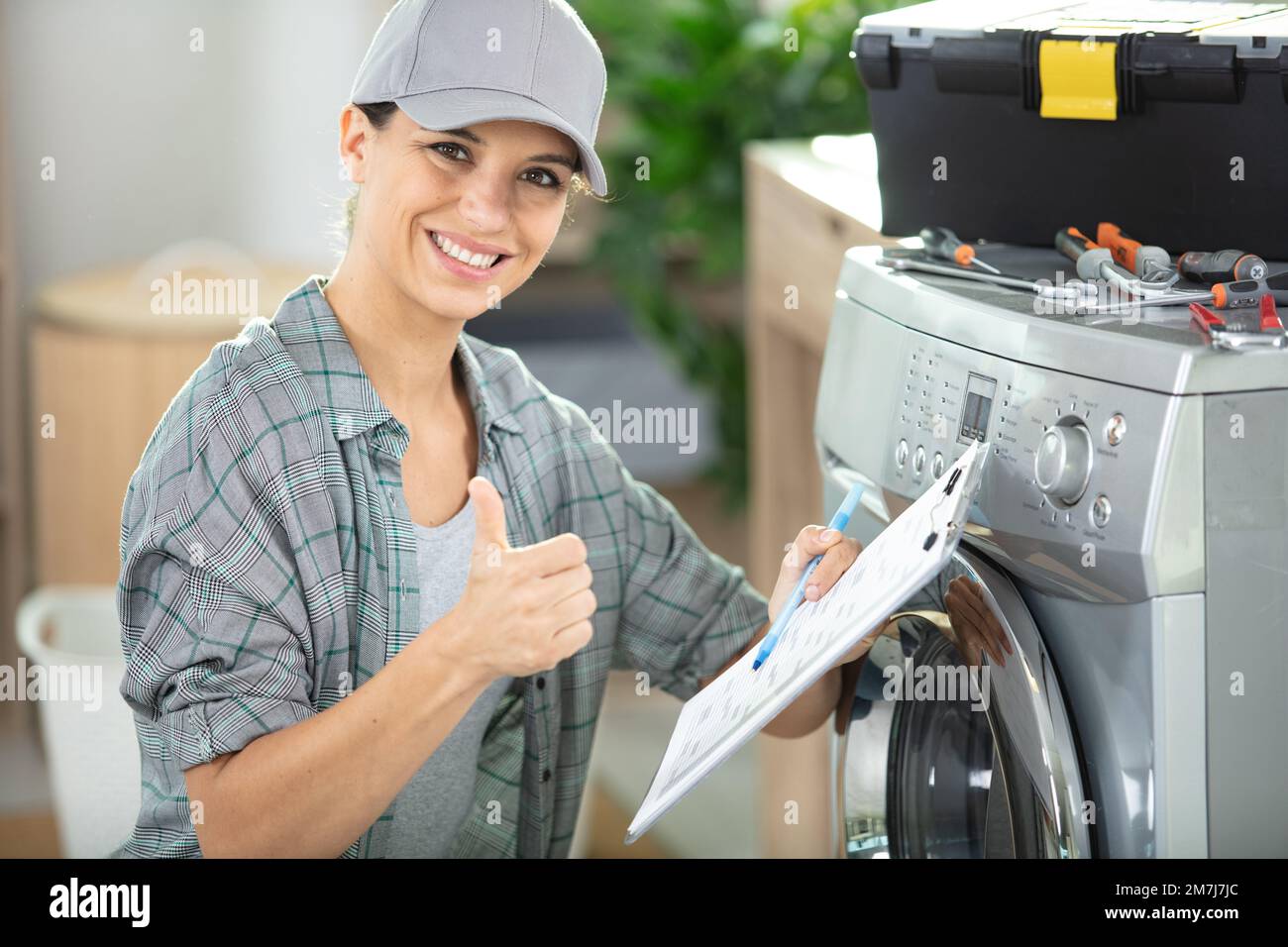 young woman repairing washing machine Stock Photo - Alamy