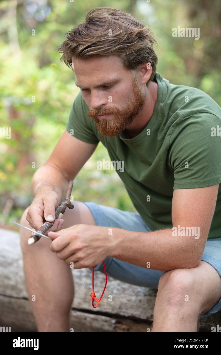 close-up of the tourist sharpening a stick with a knife Stock Photo - Alamy