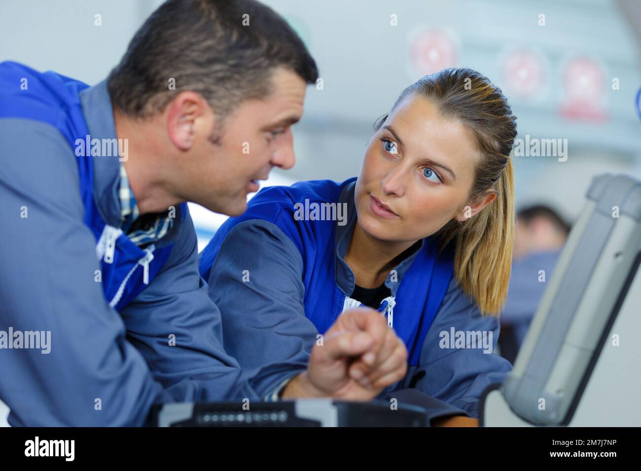 portrait of two modern mechanics talking Stock Photo - Alamy