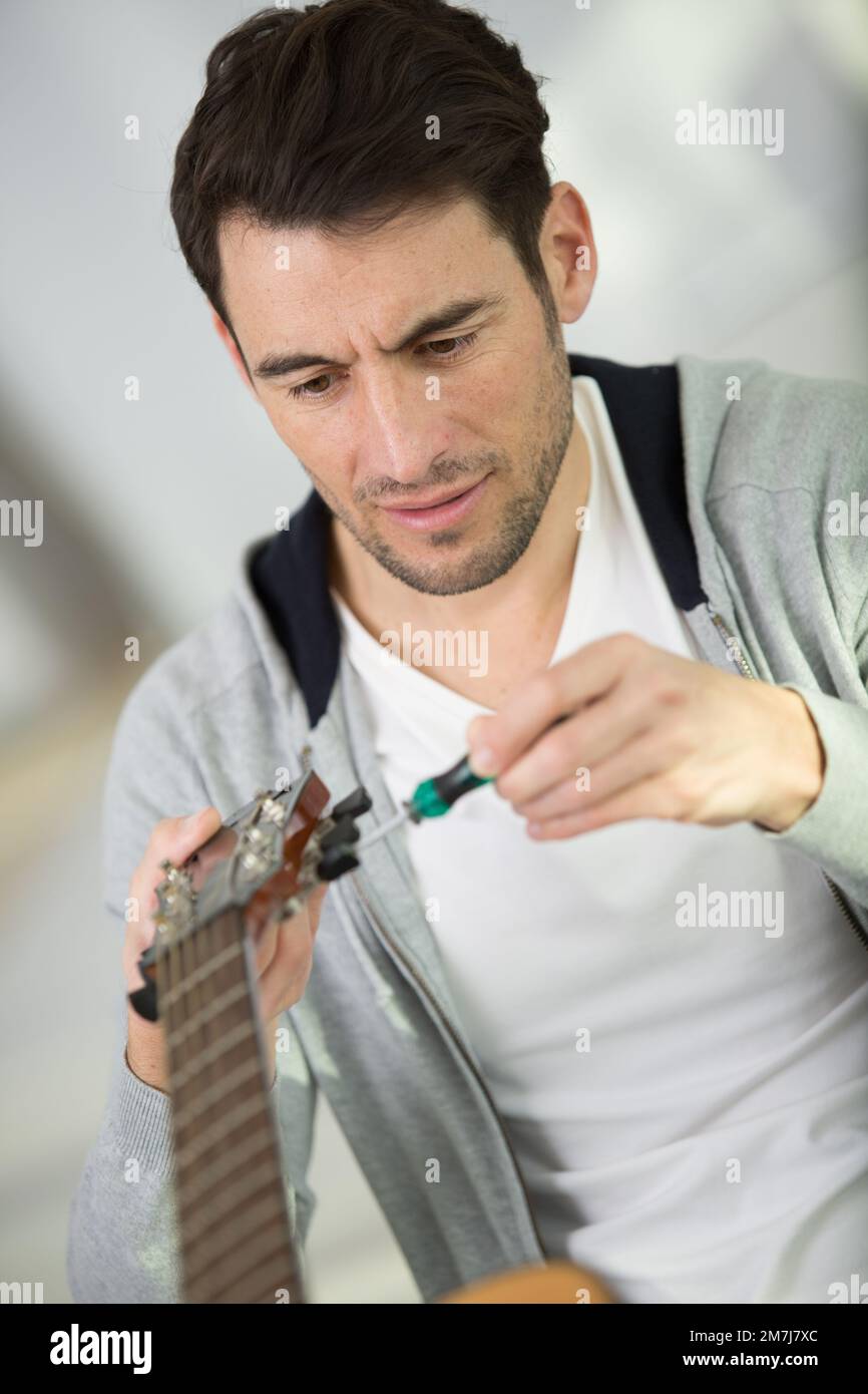 a man changes guitar strings Stock Photo - Alamy