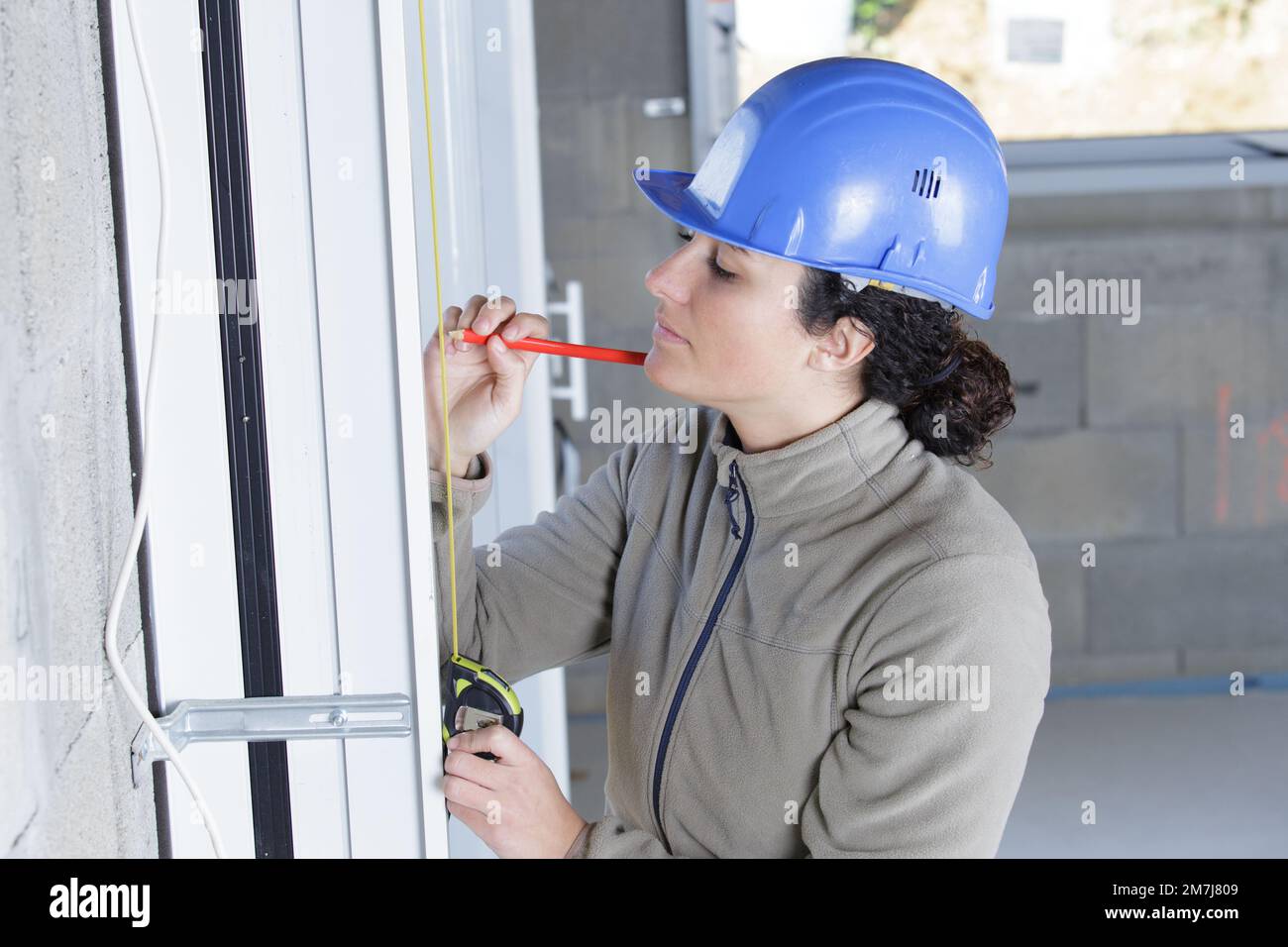 portrait of woman measuring window frame Stock Photo - Alamy