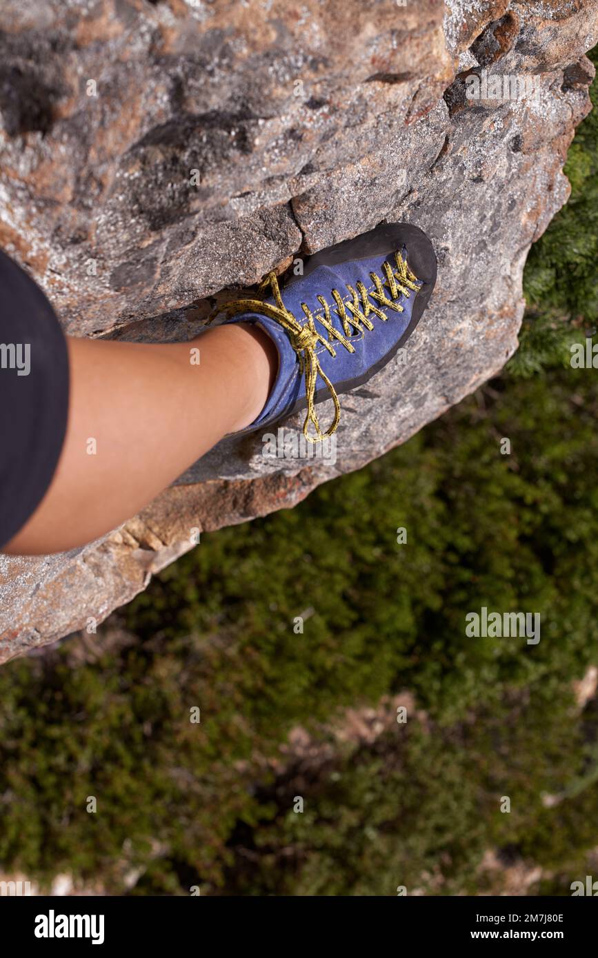 Sure-footedness. Closeup shot of a rock climbers leg standing on a ...
