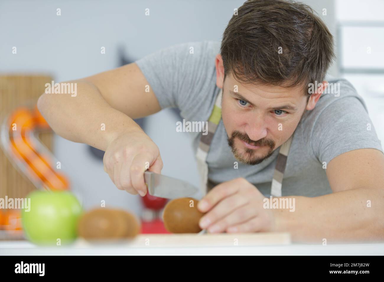 man cutting tomatoes on cutting board Stock Photo - Alamy