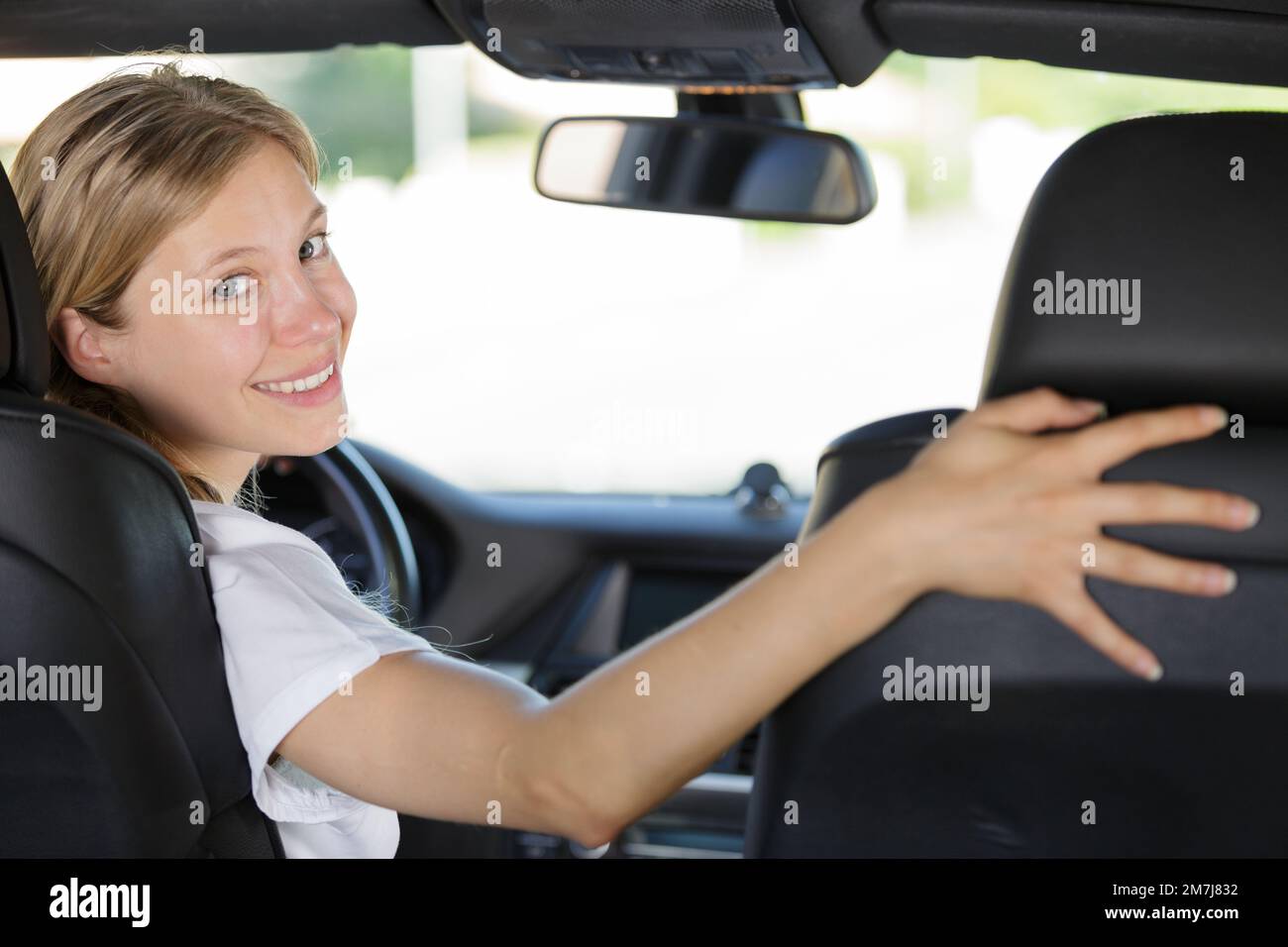 woman driving car looking backwards Stock Photo - Alamy