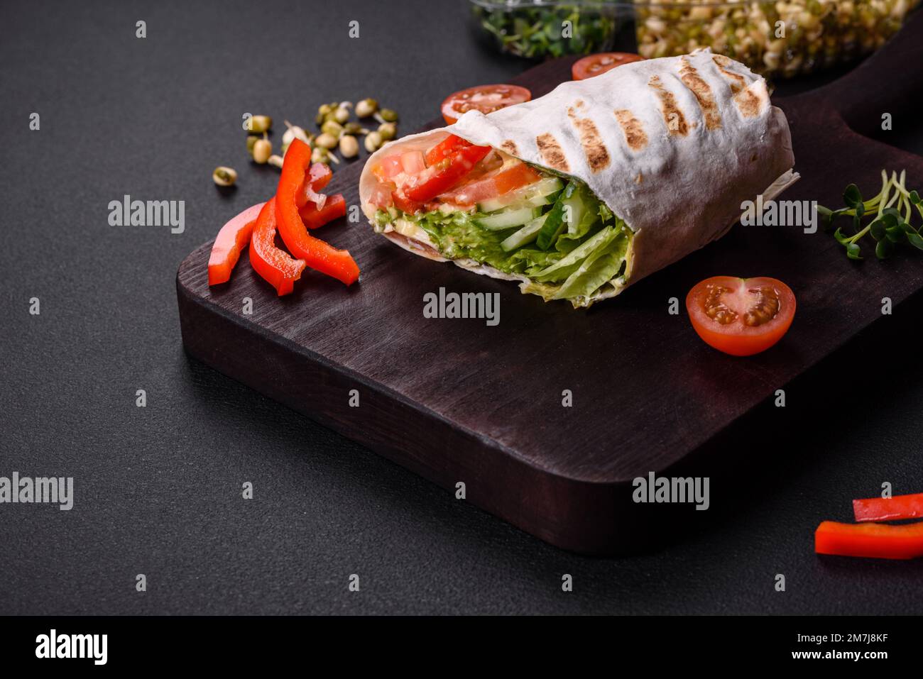 Delicious fresh shawarma with tomatoes, peppers, cucumber and sauces on ...