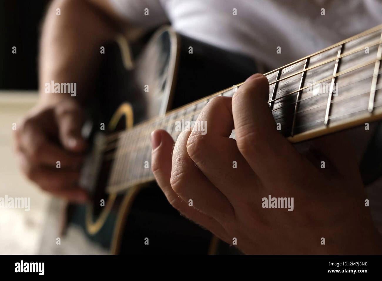 Playing the guitar. Strumming acoustic guitar. Musician plays music ...