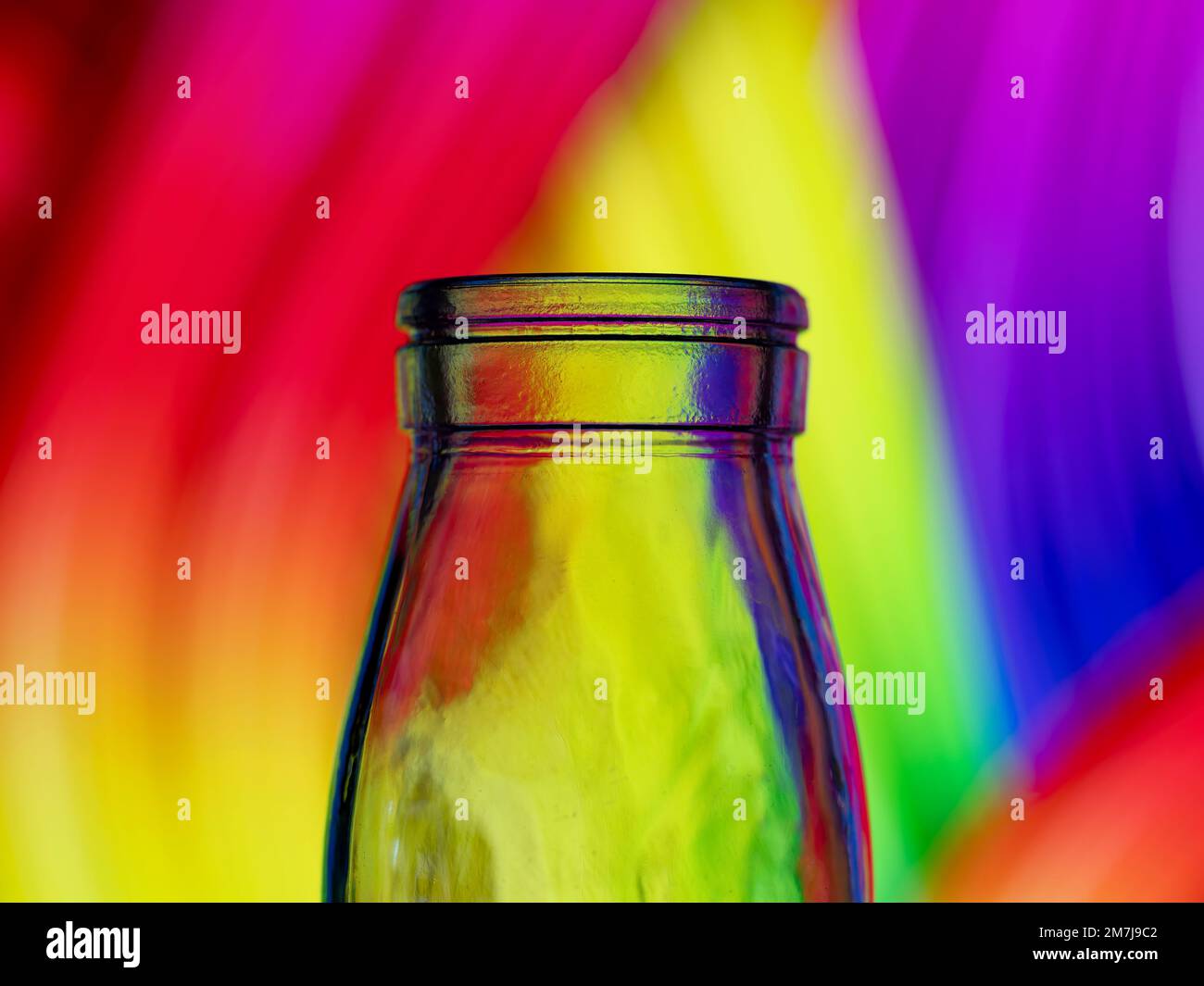 Close up of the top of a glass bottle photographed against a multi ...