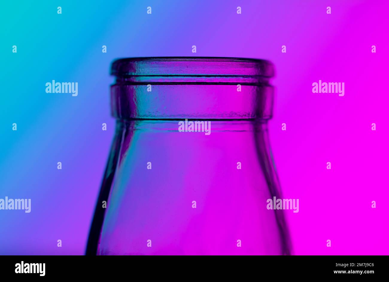 Close up of the top of a glass bottle photographed against a multi ...