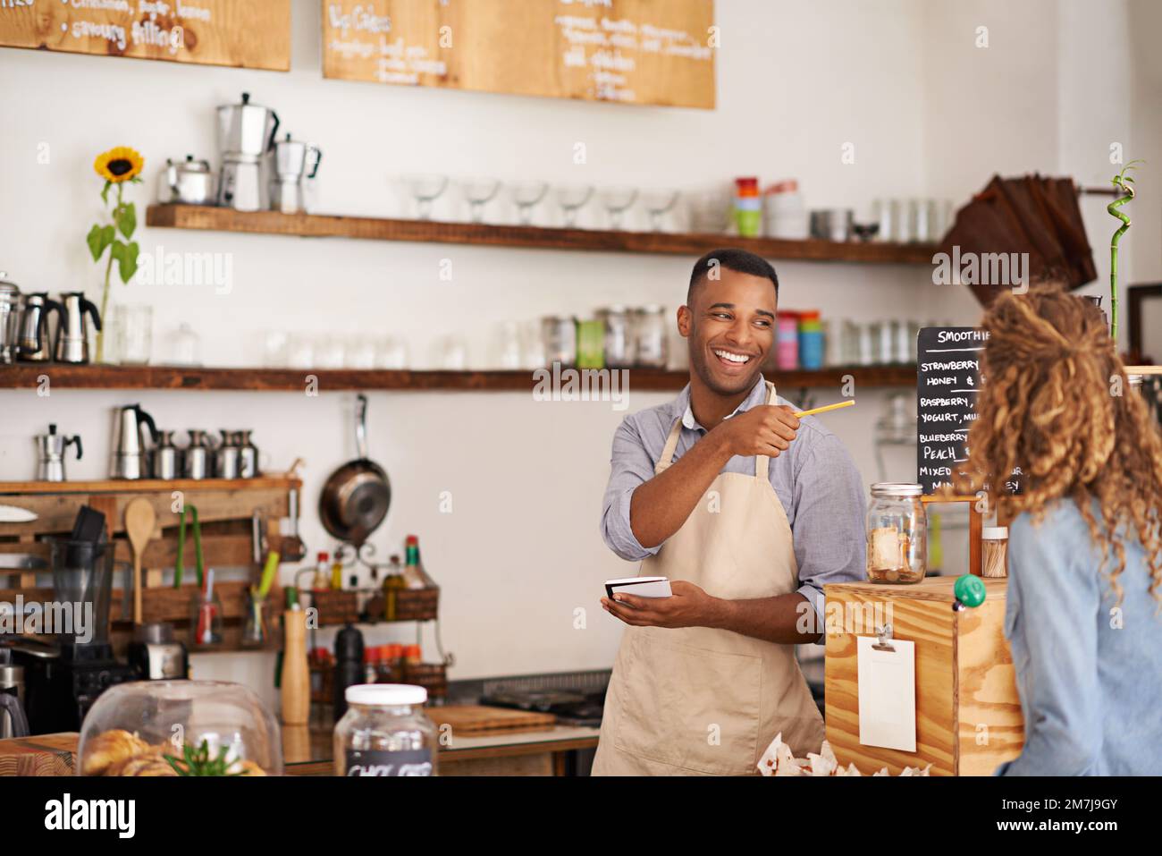 Youre a woman who knows her coffee. young barista taking a customers ...