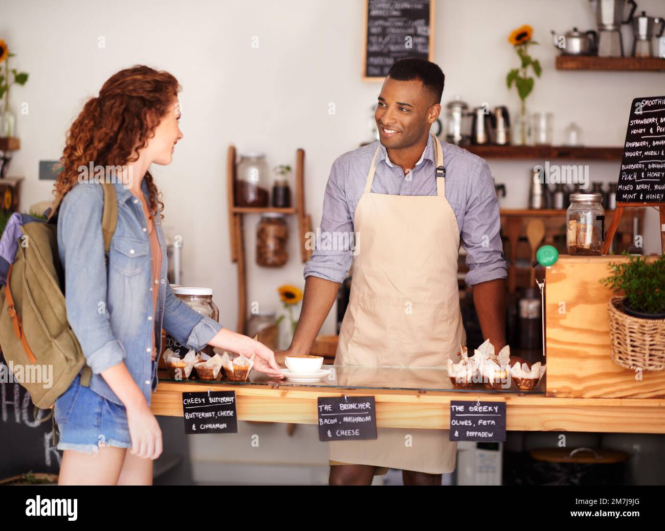 He knows how to take care of his customers. young barista serving a ...