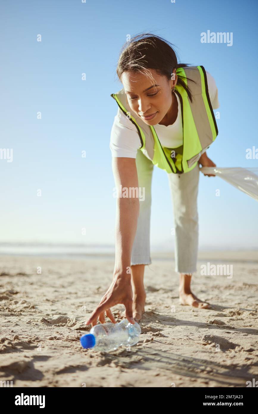 Volunteer, charity and beach cleanup with a black woman picking up ...