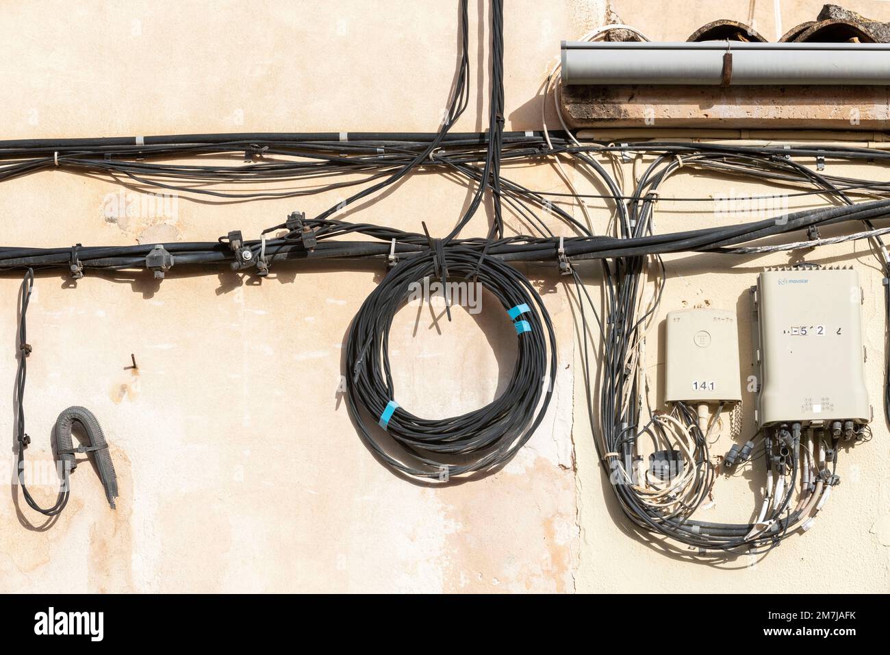 Cable clutter on a house wall in Porto Cristo, Mallorca Stock Photo - Alamy