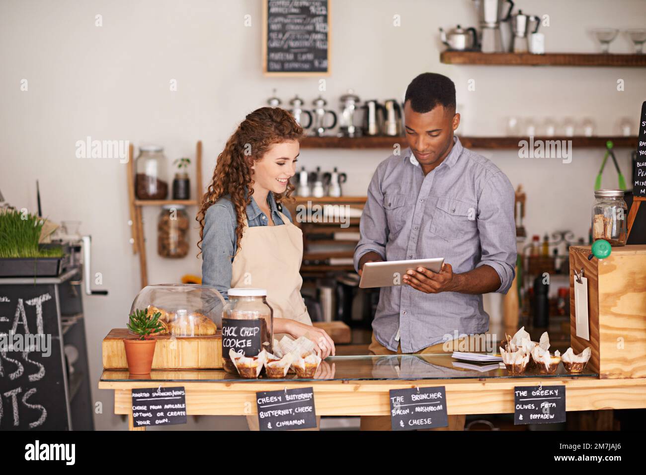 Running the cafe the wireless way. young baristas using a digital ...