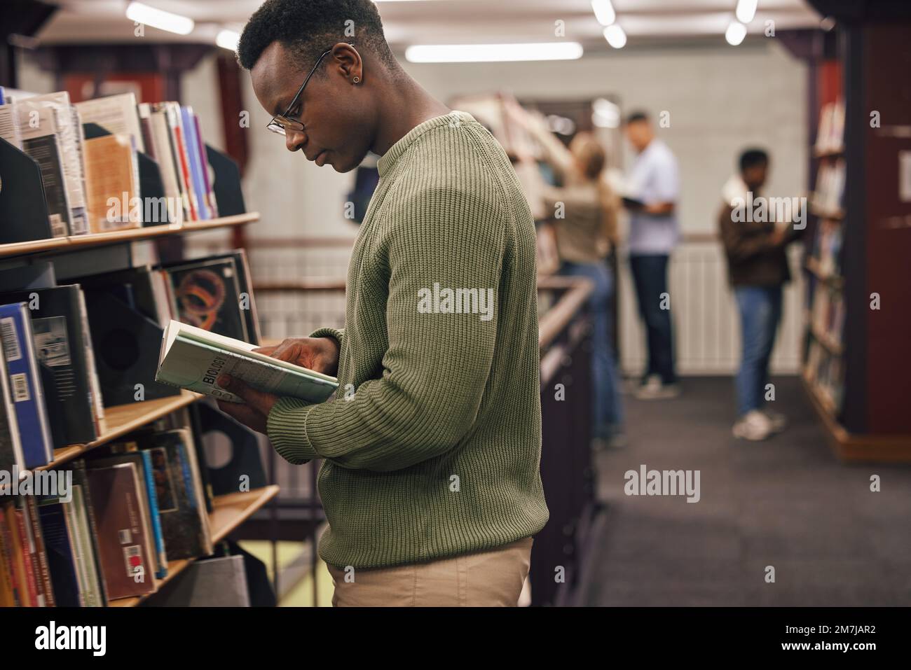 Black man student, reading and library with book, research and ...