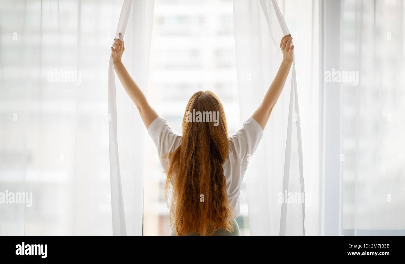 Woman opening the window in the bedroom in the morning Stock Photo - Alamy