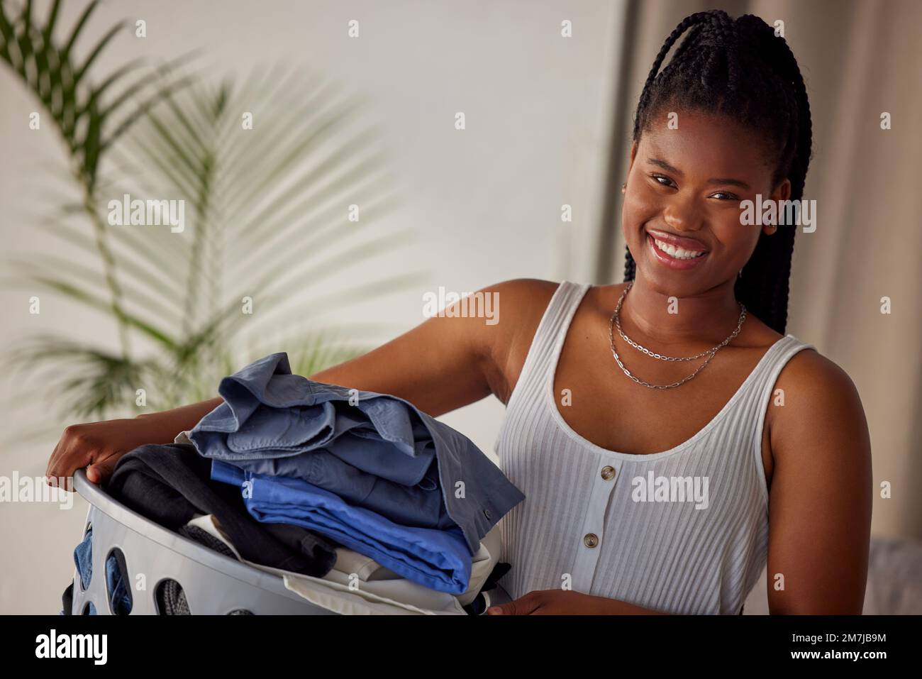 Laundry, basket and portrait of black woman with clothes folded ...