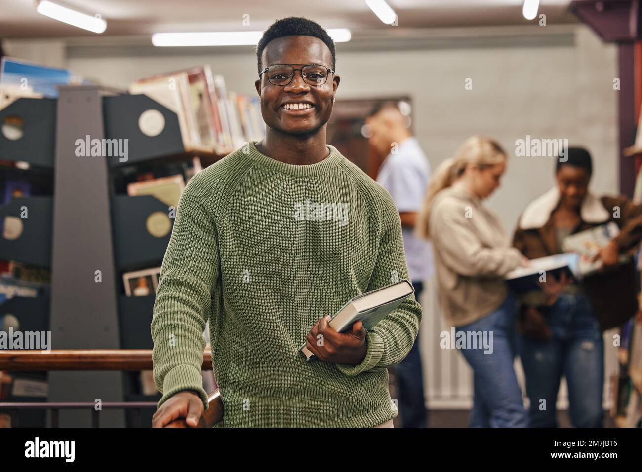 Black man, book and portrait in library with smile, research and ...