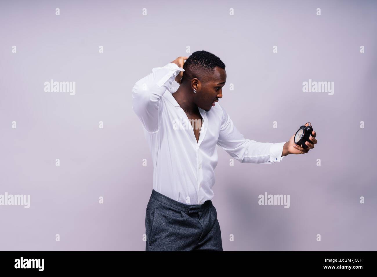 Time Management Concept. Shocked black man holding wall clock, running ...