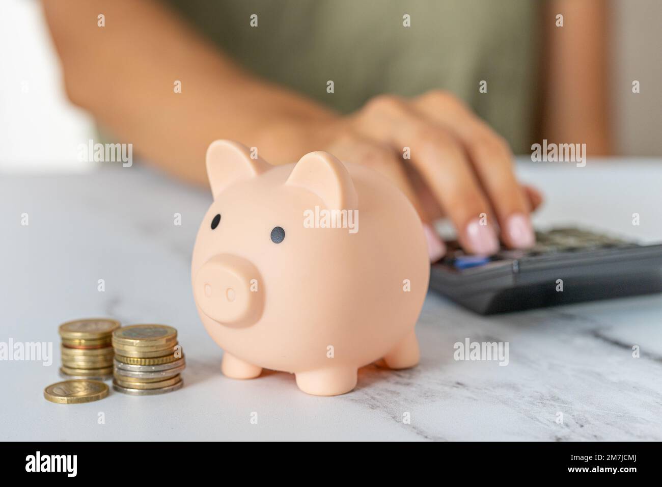 Close-up of a woman's hands counting expenses on a calculator with a ...