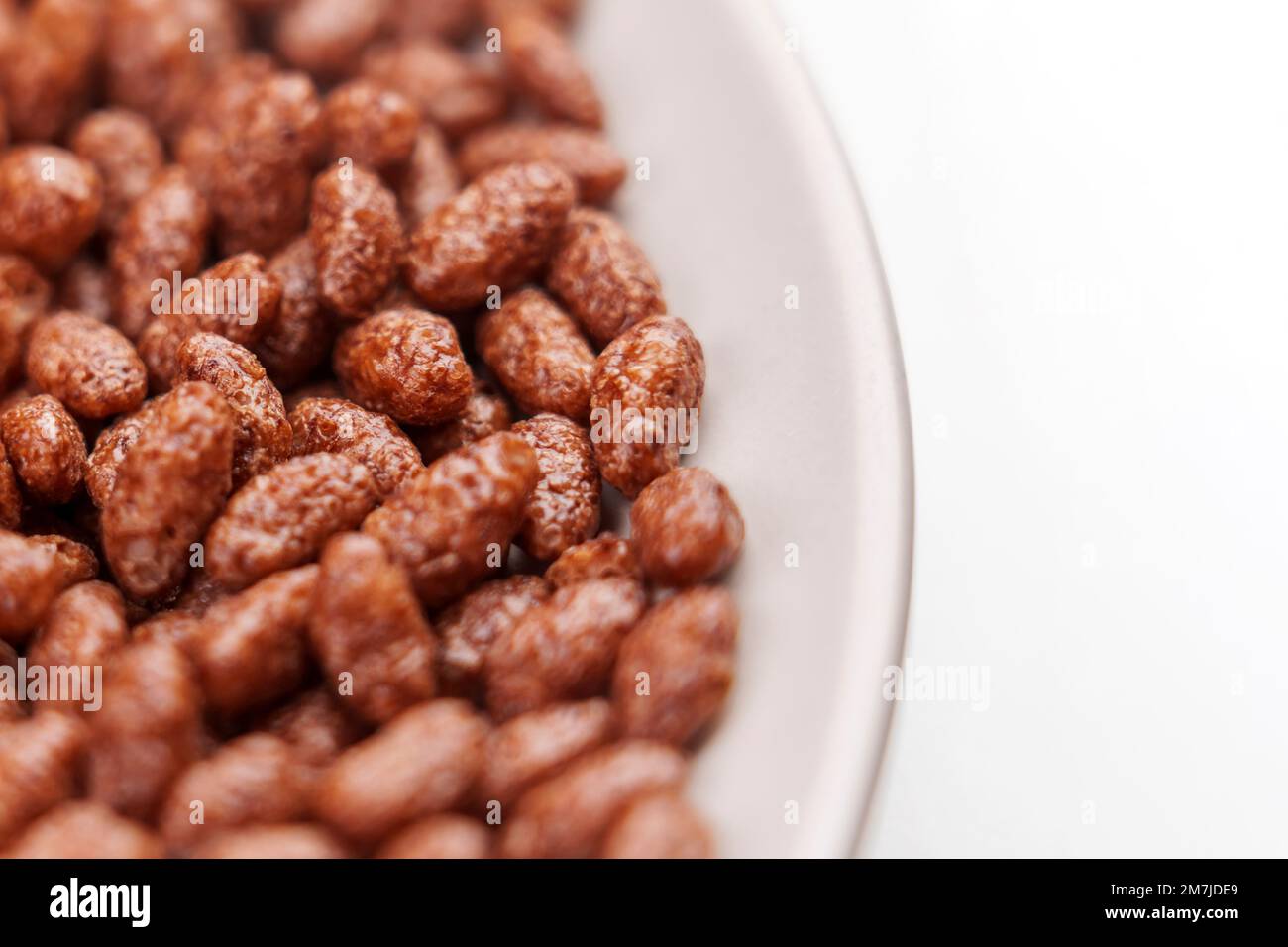 Chocolate cereal puffed rice grains in plate close up. Crunchy healthy ...