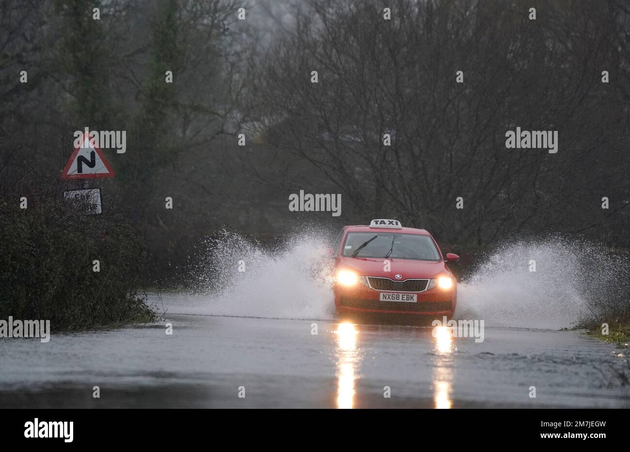 A car makes it's way through flood water on Kent Lane, near to Ibsley ...