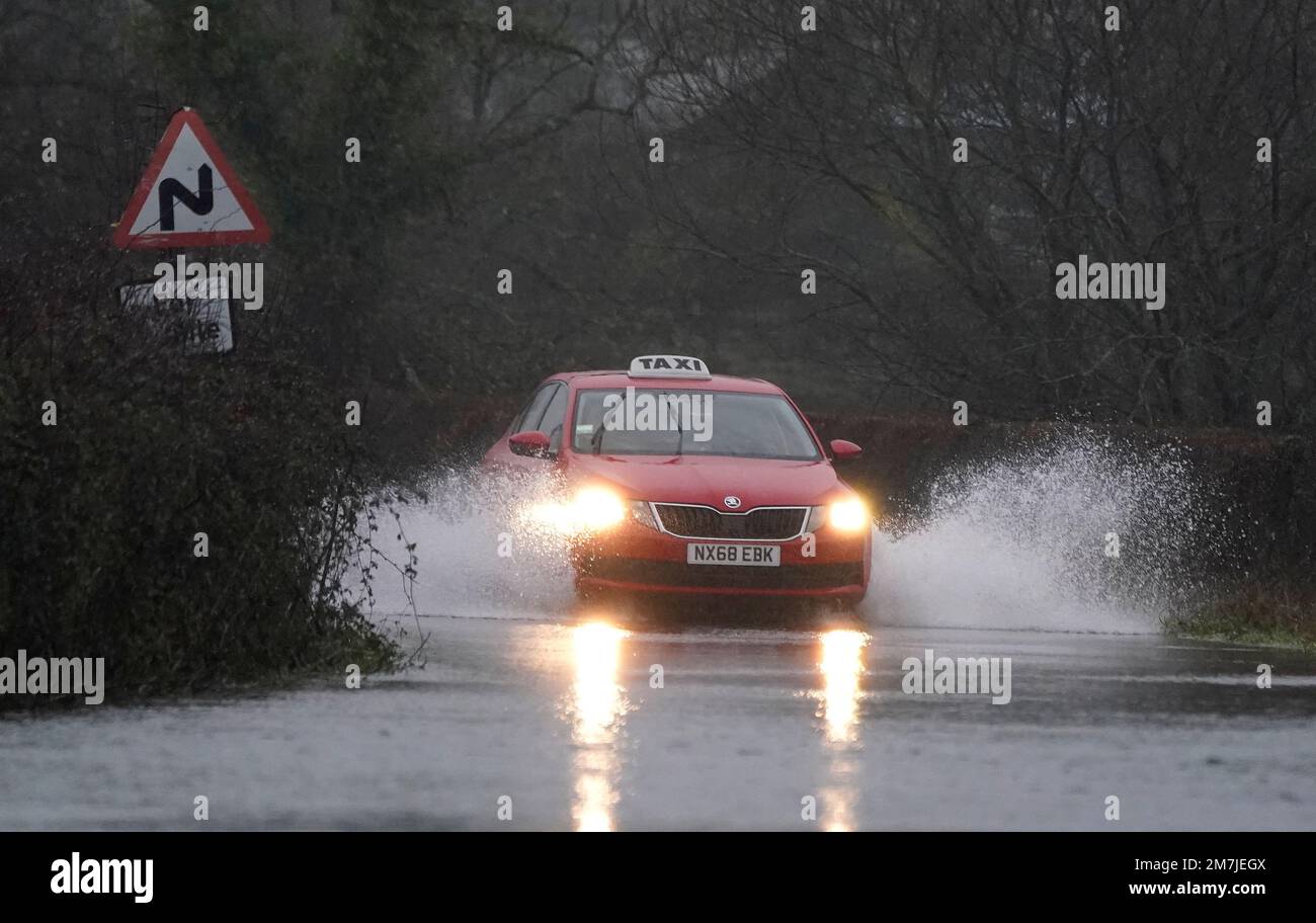 A car makes it's way through flood water on Kent Lane, near to Ibsley ...