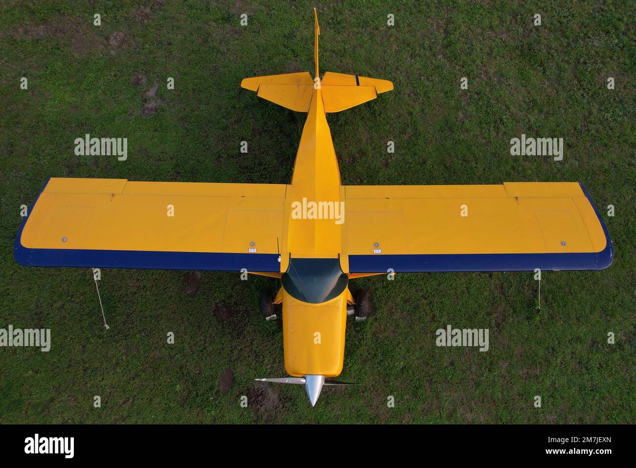small yellow plane used for short trips seen from above parked on a ...