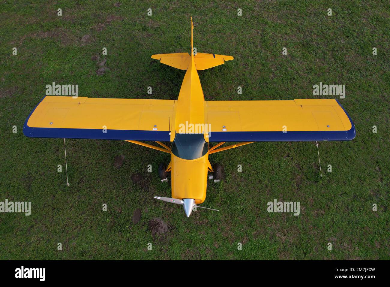 small yellow plane used for short trips seen from above parked on a ...