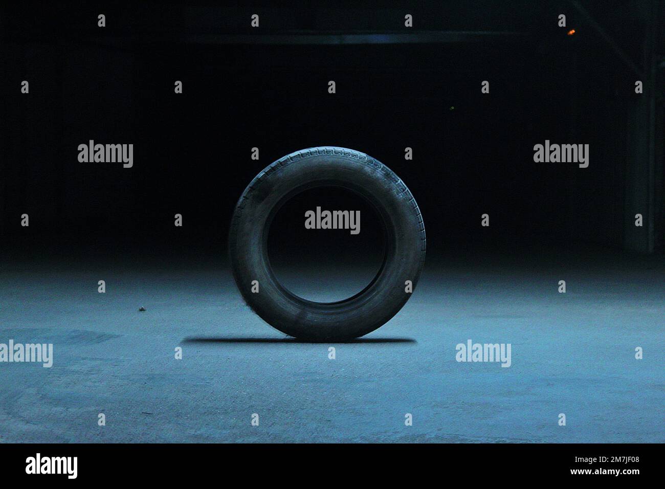 A car tire in the ground on a dark background Stock Photo - Alamy