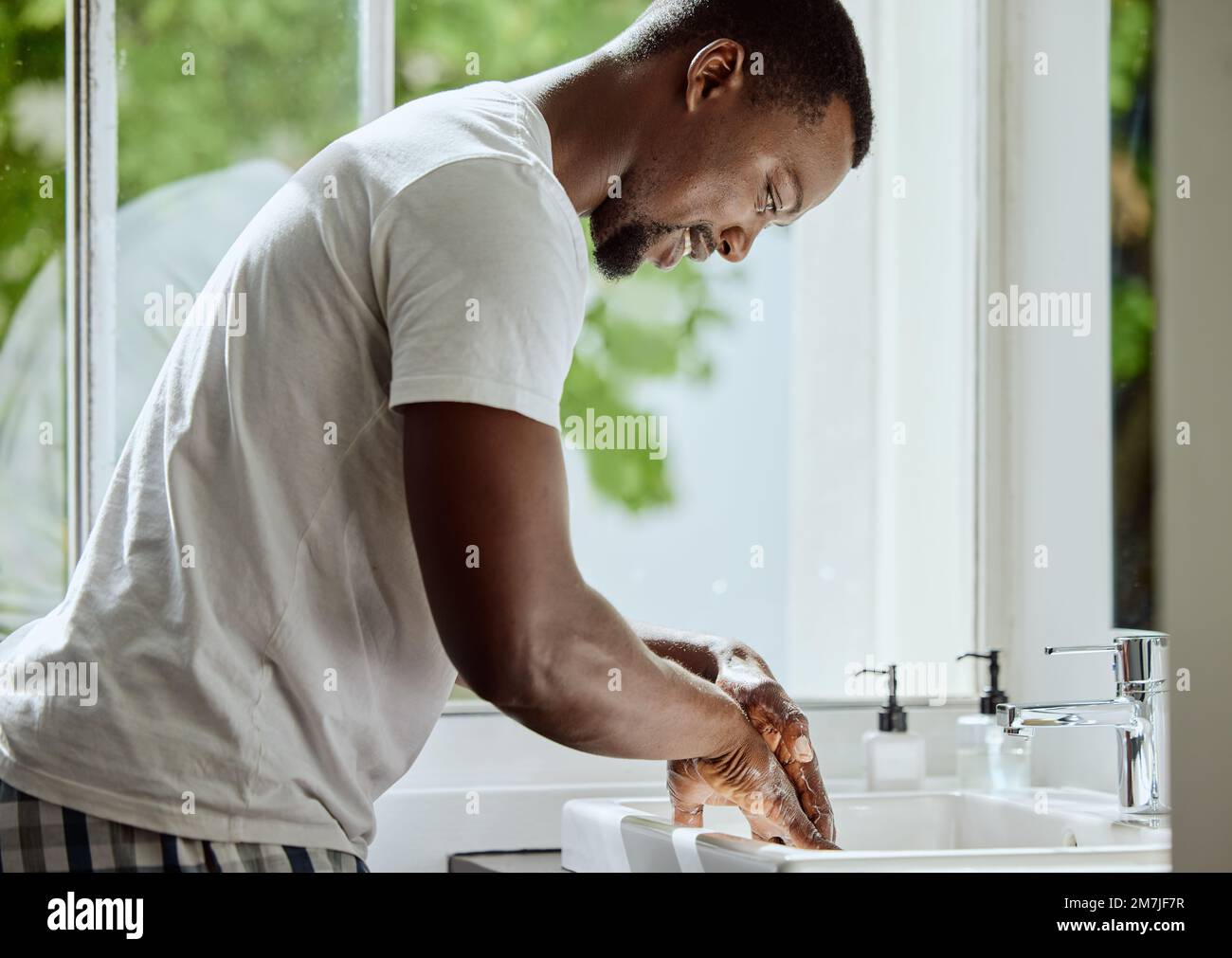 Black man, washing hands or bathroom sink soap in home healthcare ...