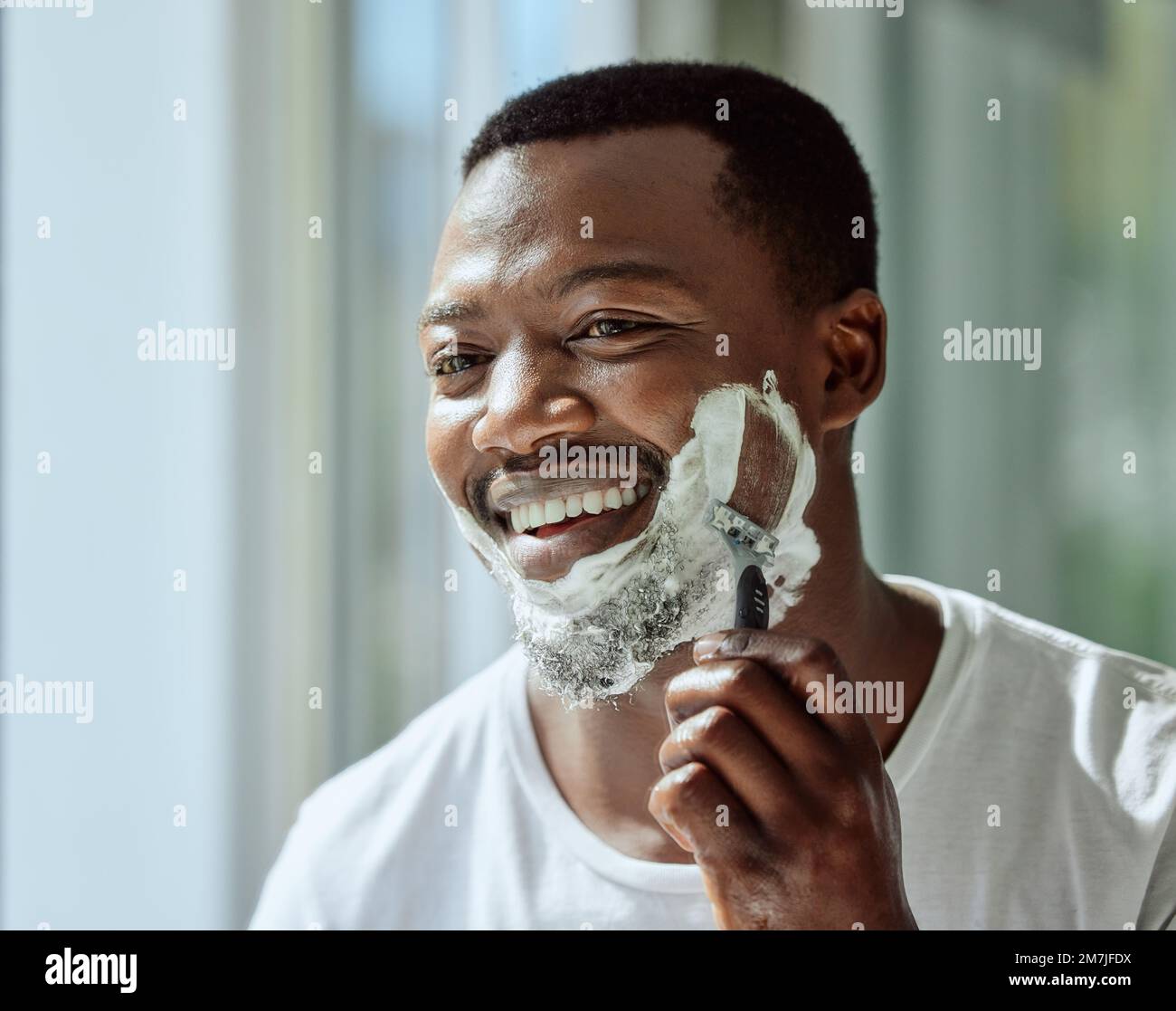 Face, shaving and razor with a black man grooming in the bathroom ...