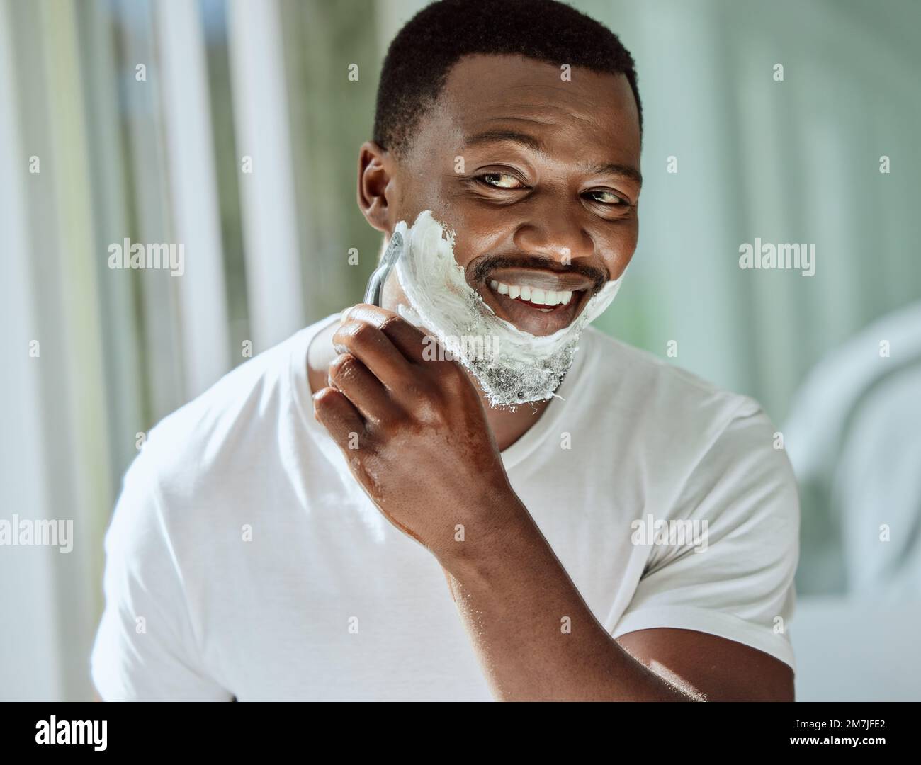 Cream, razor and shaving black man in the bathroom for skincare, beard grooming routine and ...