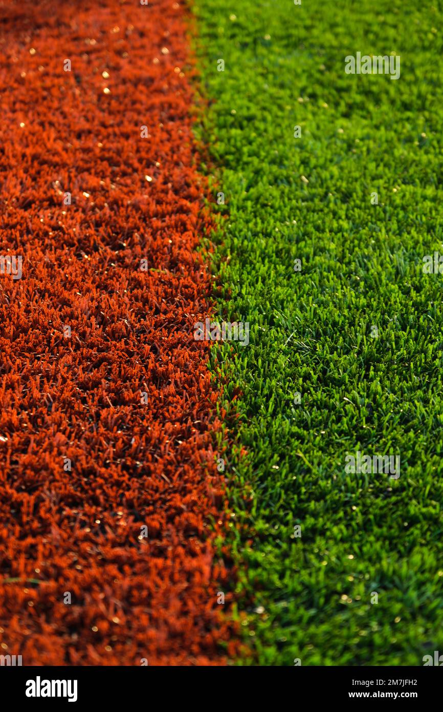 Close up shot of red and green colored artificial grass in a football ...