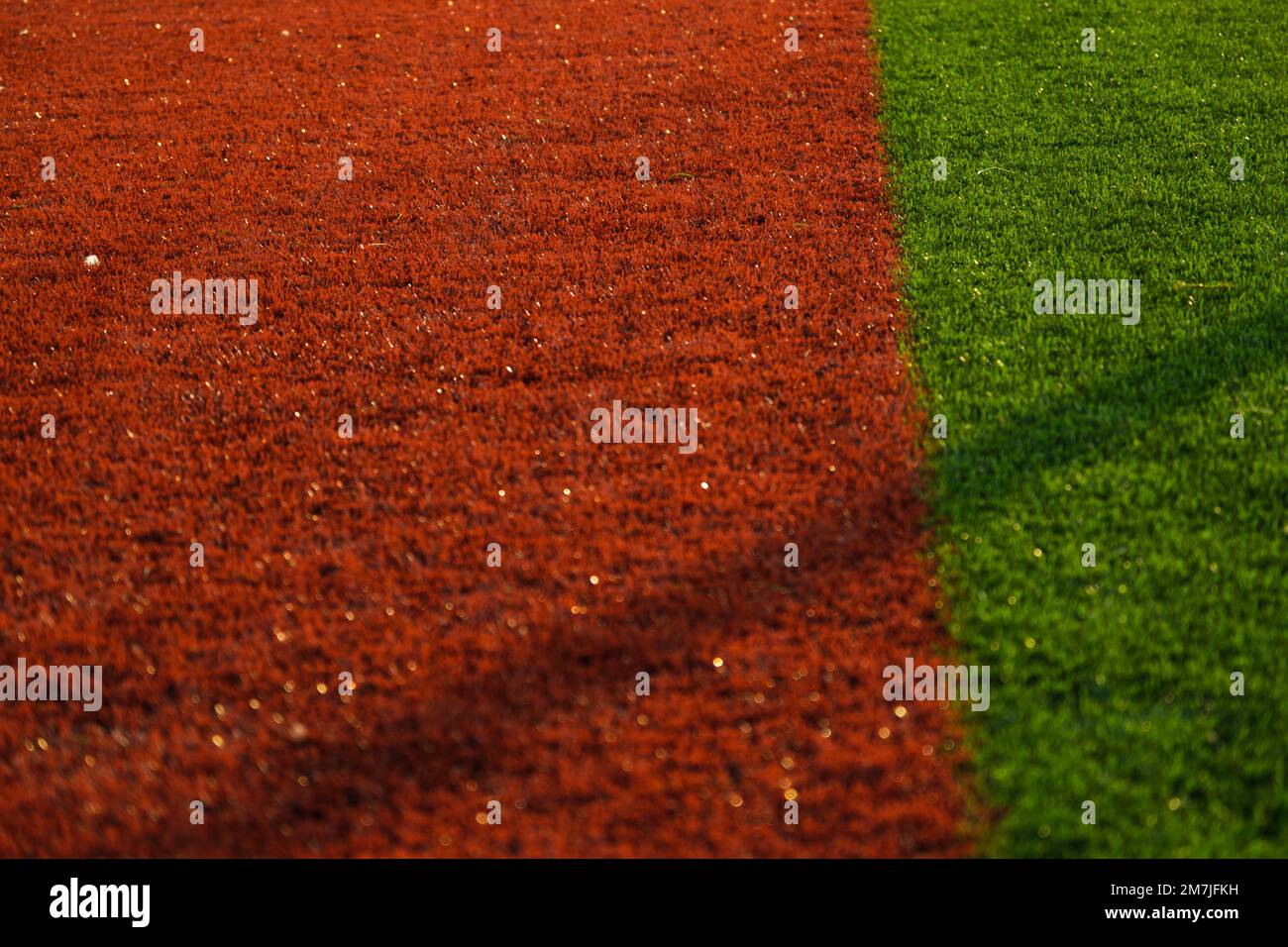 Close up shot of red and green colored artificial grass in a football ...