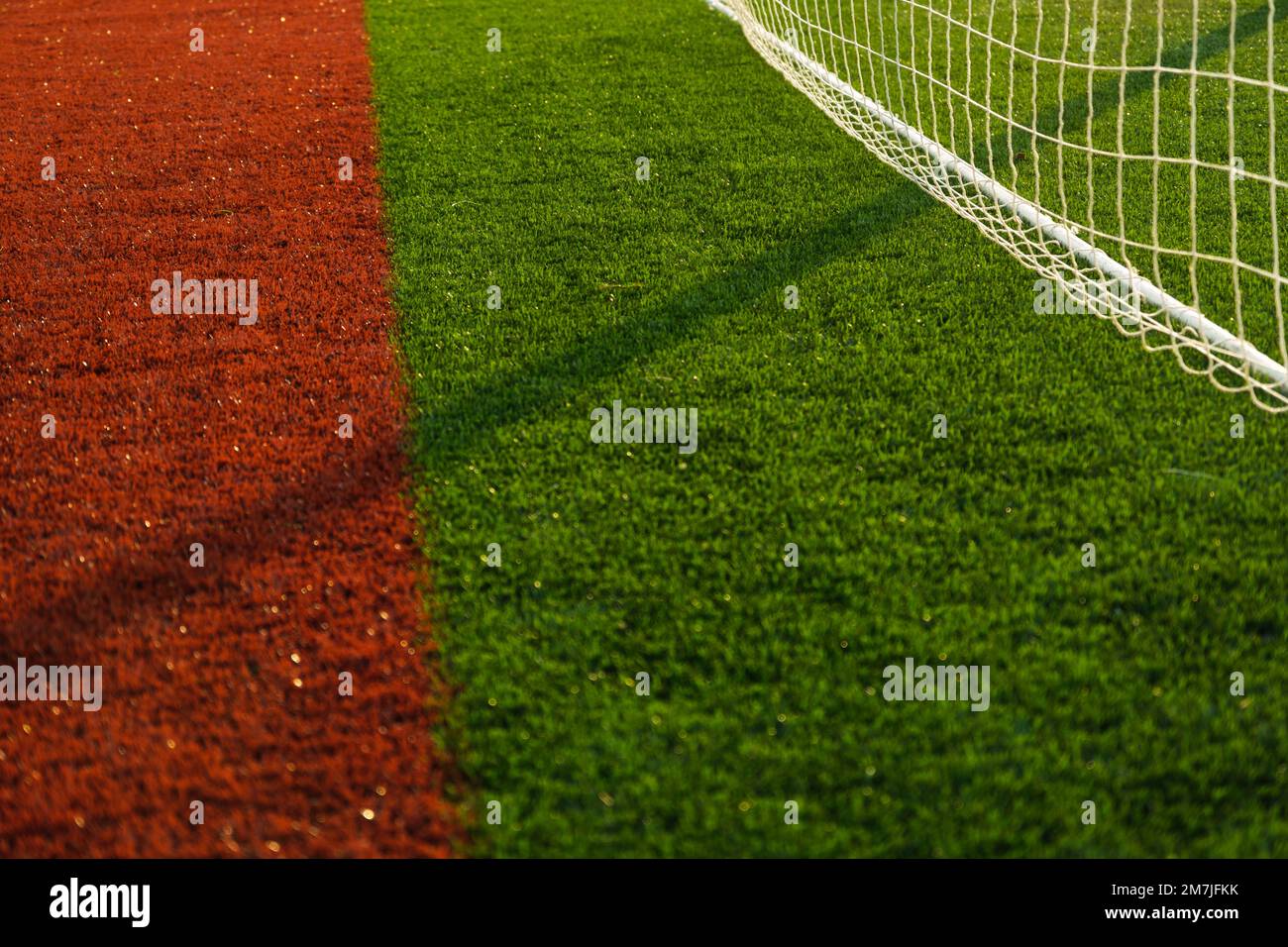 Close up shot of red and green colored artificial grass in a football ...