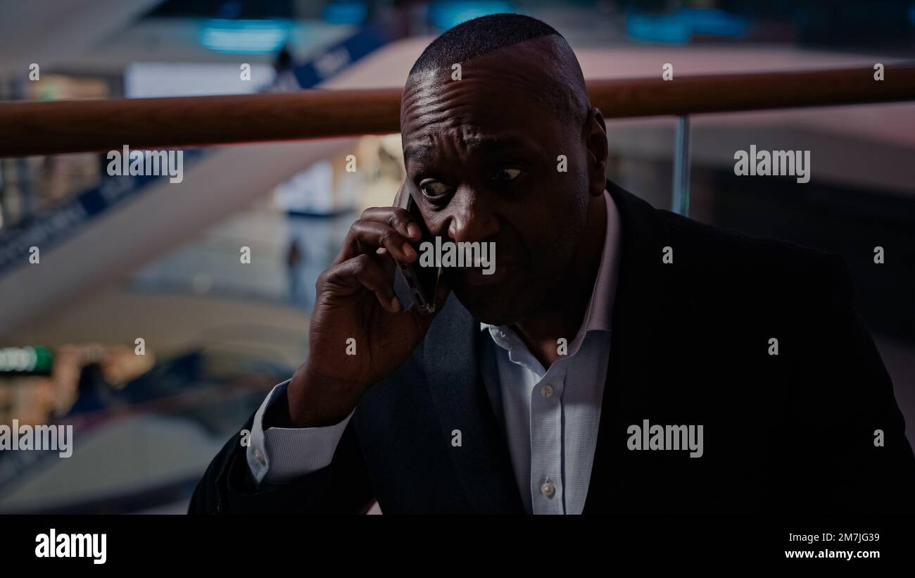 Pensive senior ethnic businessman sad answer call displeased talking ...