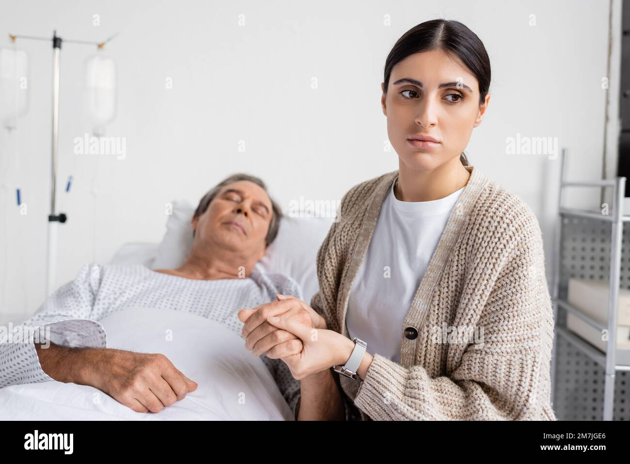 Sad woman holding hand of sick father in hospital ward,stock image ...